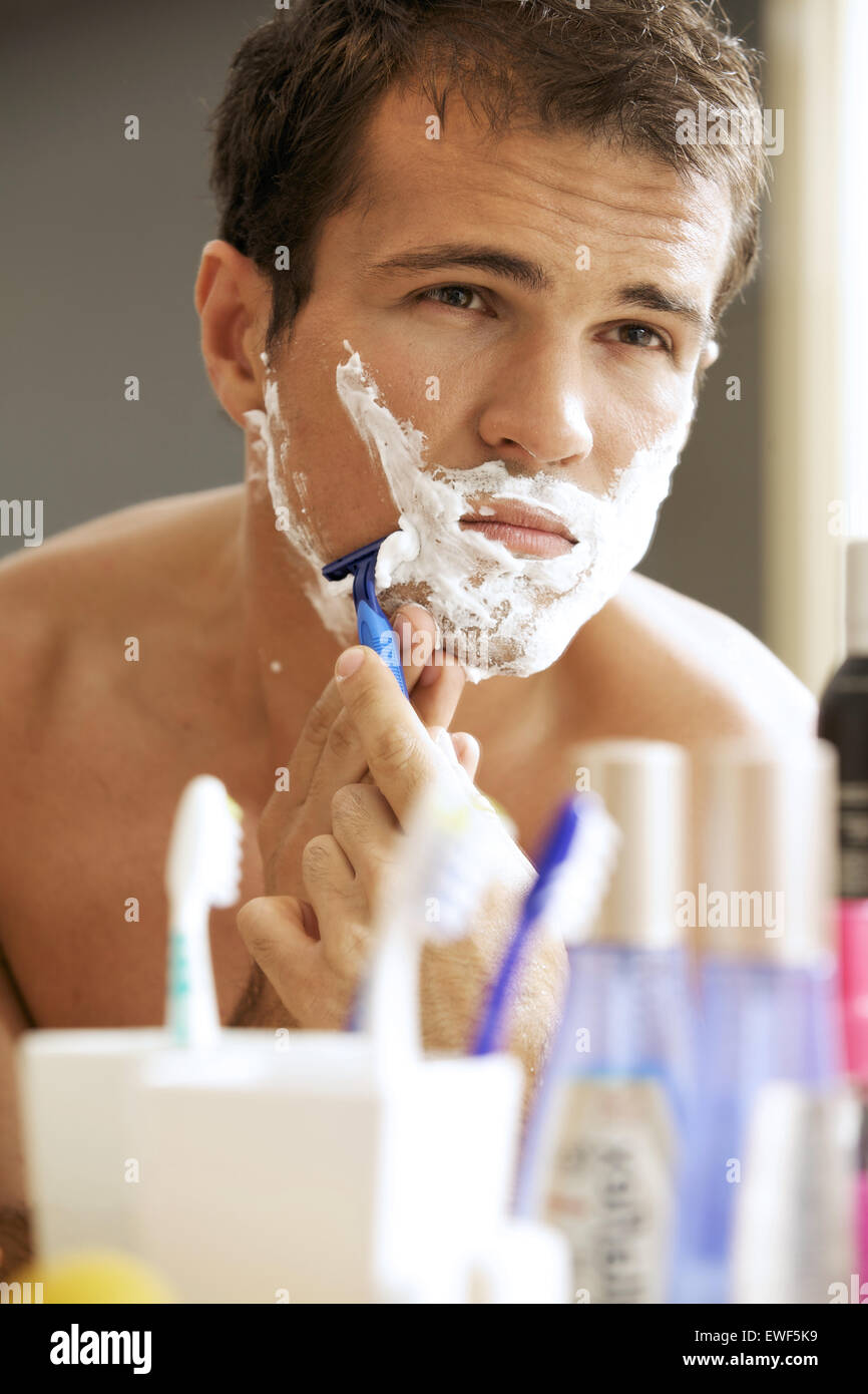 Young man shaving Stock Photo - Alamy