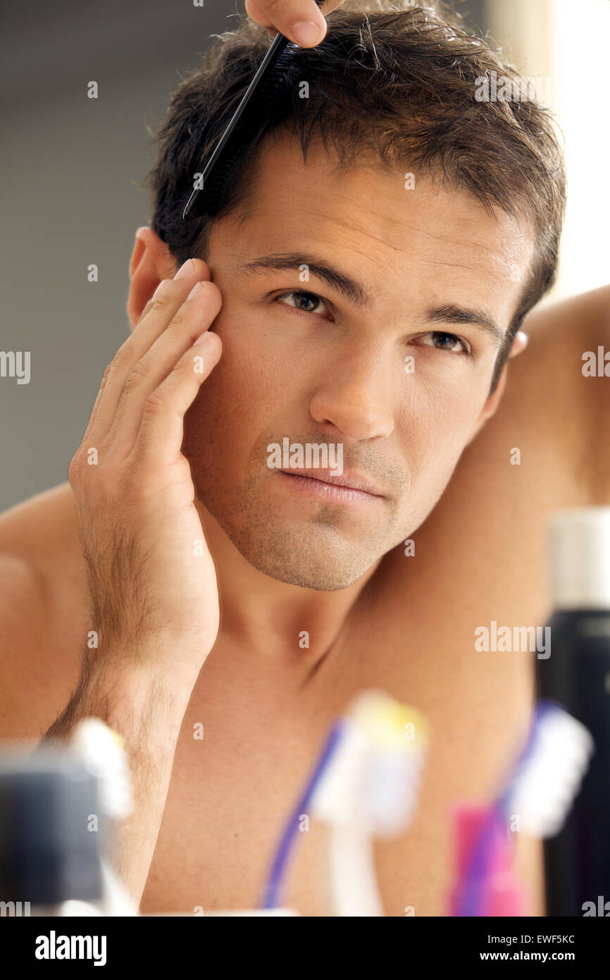 Young man combing his hair Stock Photo - Alamy