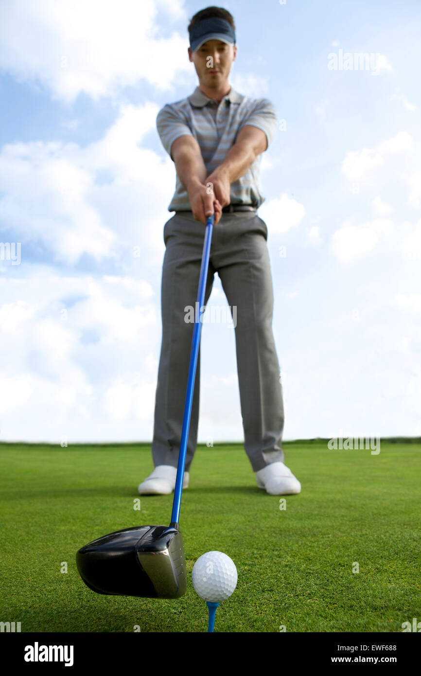 Man about to strike golf ball, low angle view Stock Photo - Alamy