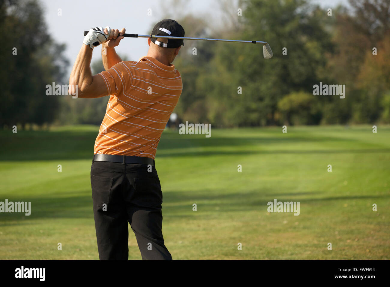 Young man swinging golf club, rear view Stock Photo - Alamy