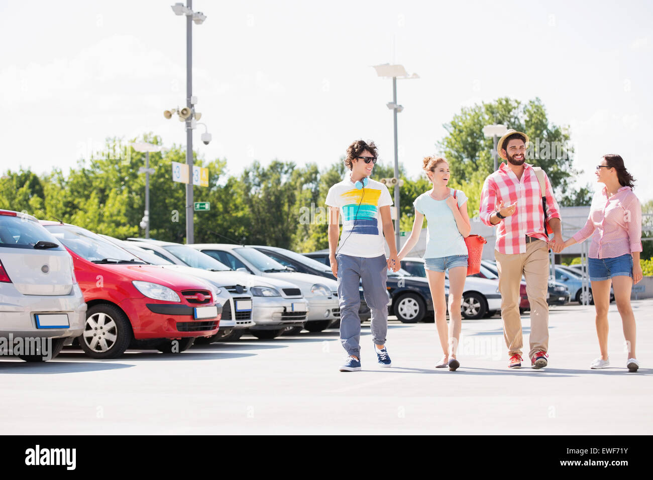 Happy friends walking on city street Stock Photo - Alamy