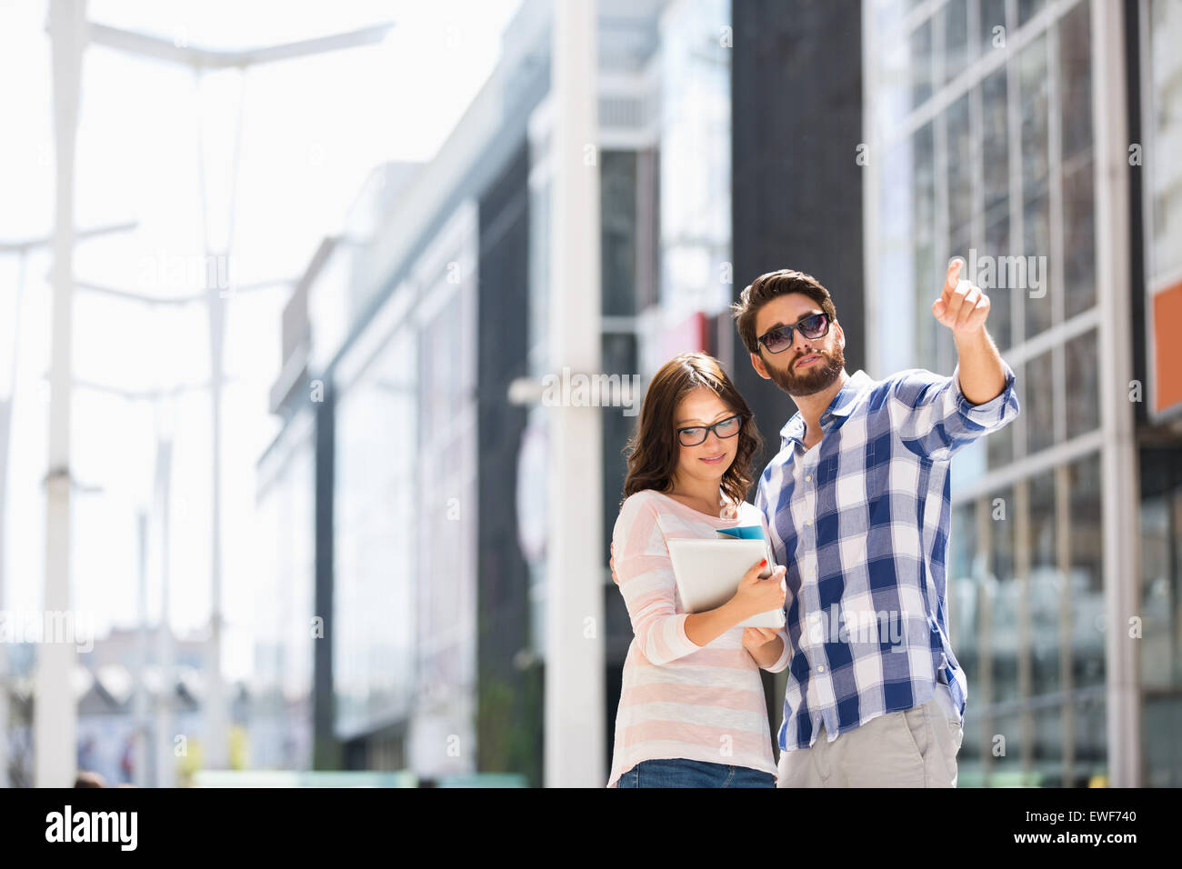 Man pointing while woman using digital tablet outside building Stock ...