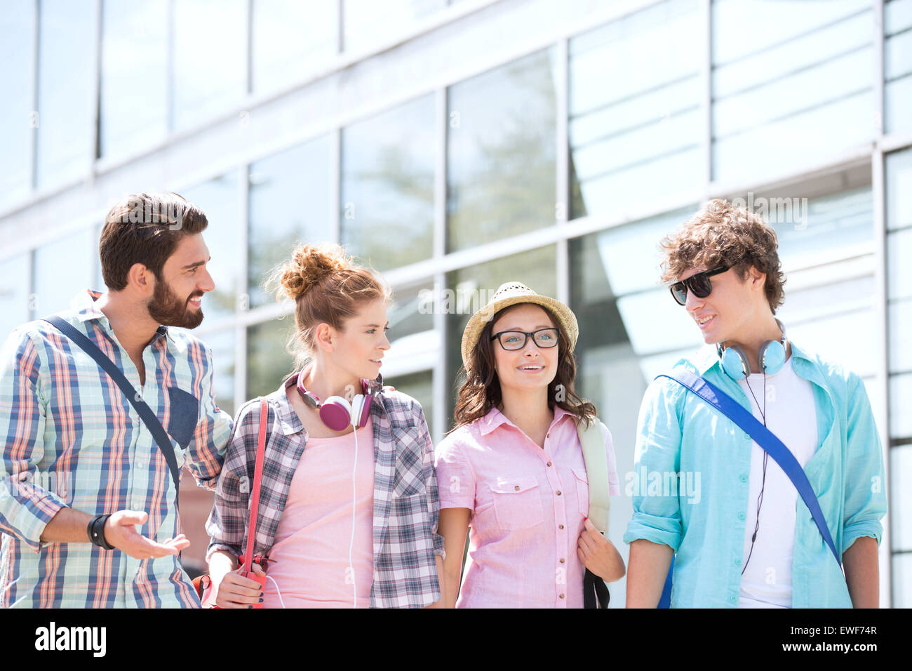 Male and female friends talking outside building Stock Photo - Alamy