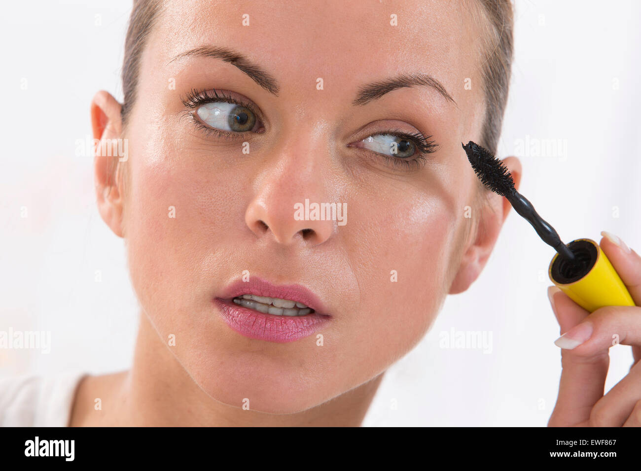 WOMAN PUTTING ON MAKE-UP Stock Photo - Alamy