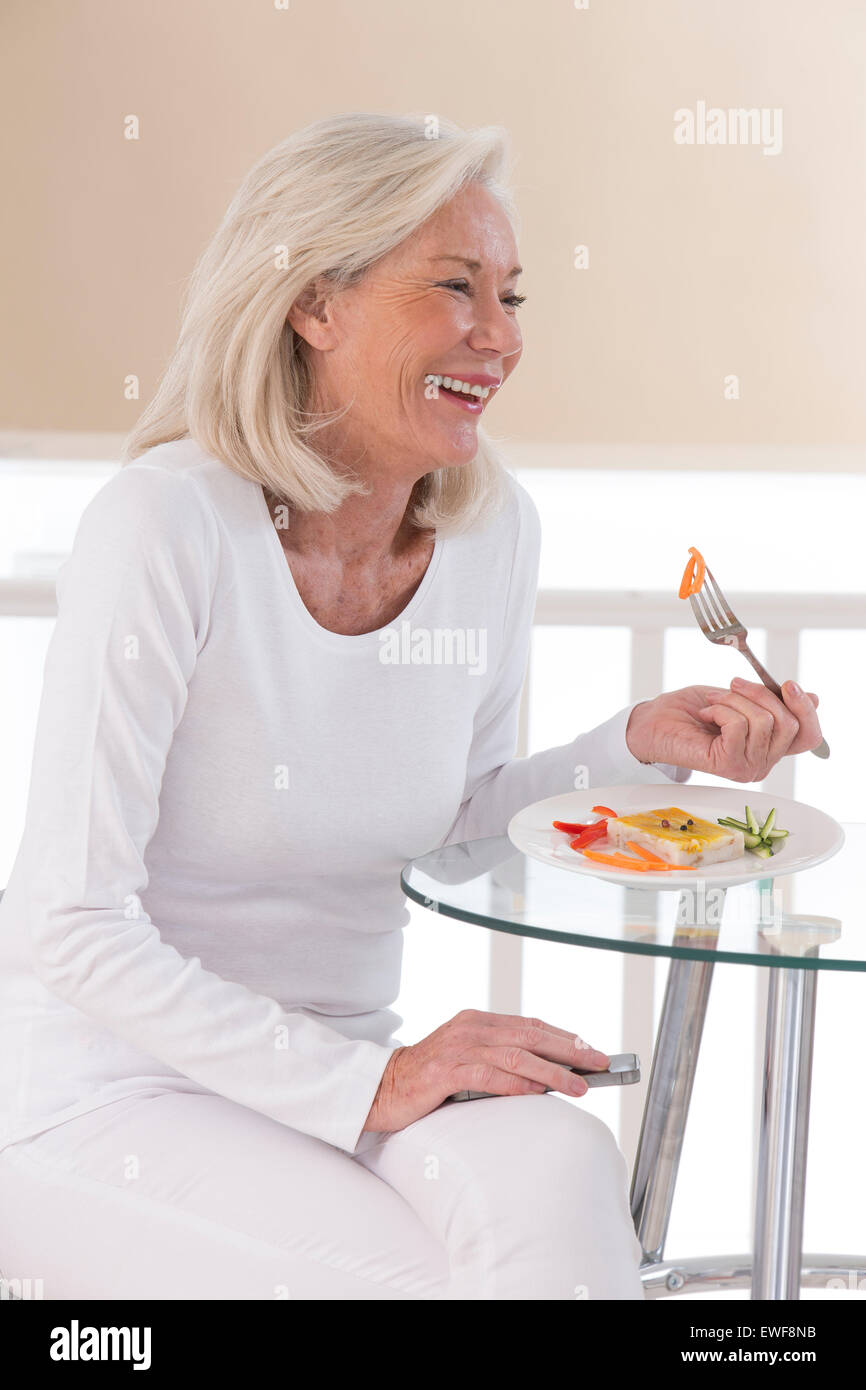 Senior woman eating fish hi-res stock photography and images - Alamy