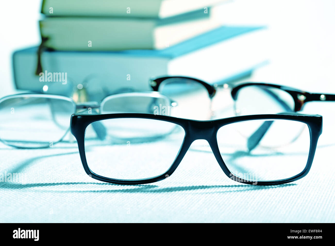 reading glasses and books on the white table Stock Photo - Alamy