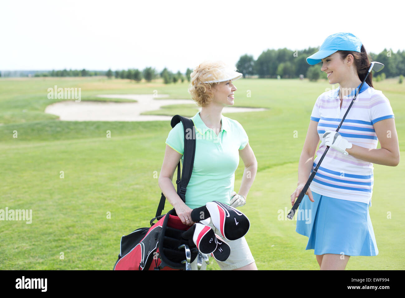 Smiling female golfers talking at golf course Stock Photo - Alamy