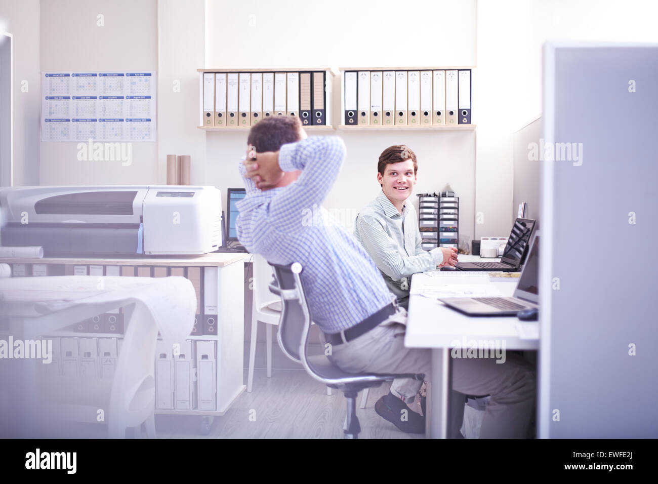 Architects talking at desk in office Stock Photo - Alamy