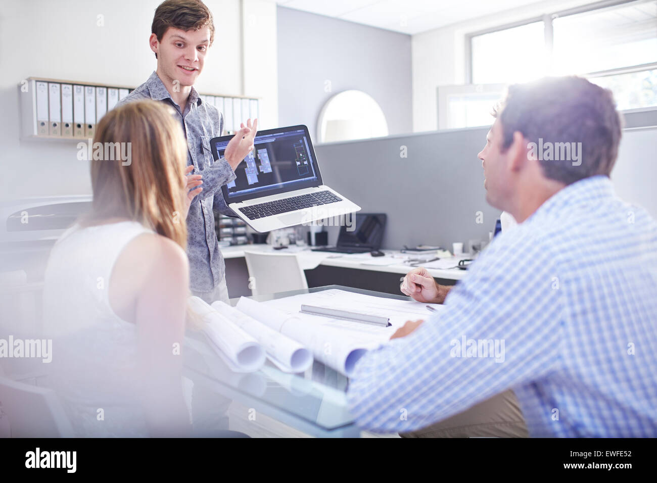 Architects meeting with laptop and blueprints in office Stock Photo - Alamy