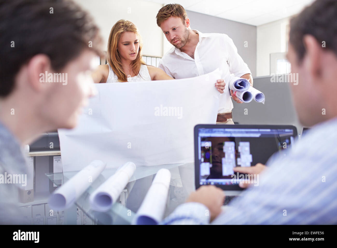 Architects reviewing blueprints in office Stock Photo - Alamy