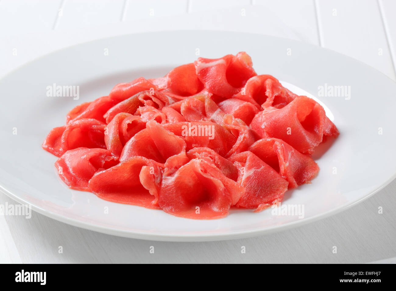 Thinly sliced raw beef meat Stock Photo - Alamy