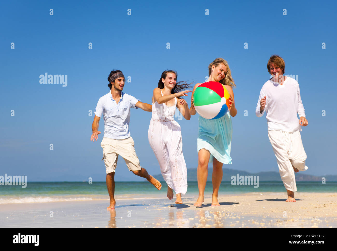 Two couple relaxing on the beach Stock Photo - Alamy