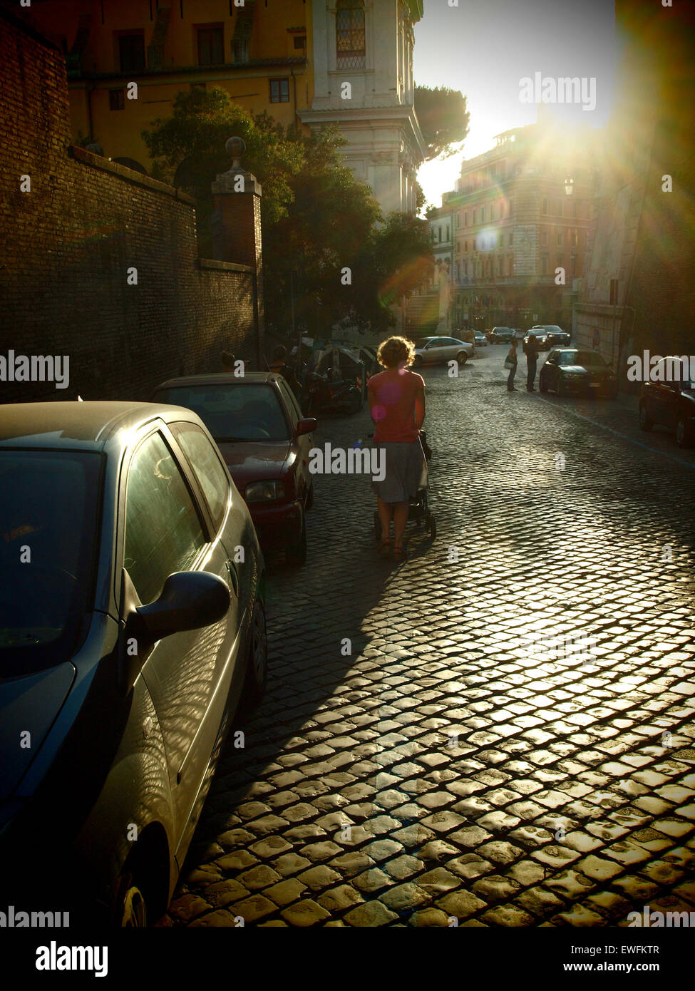 Woman backlit on an old cobblestone street in the evening, Rome, Italy ...