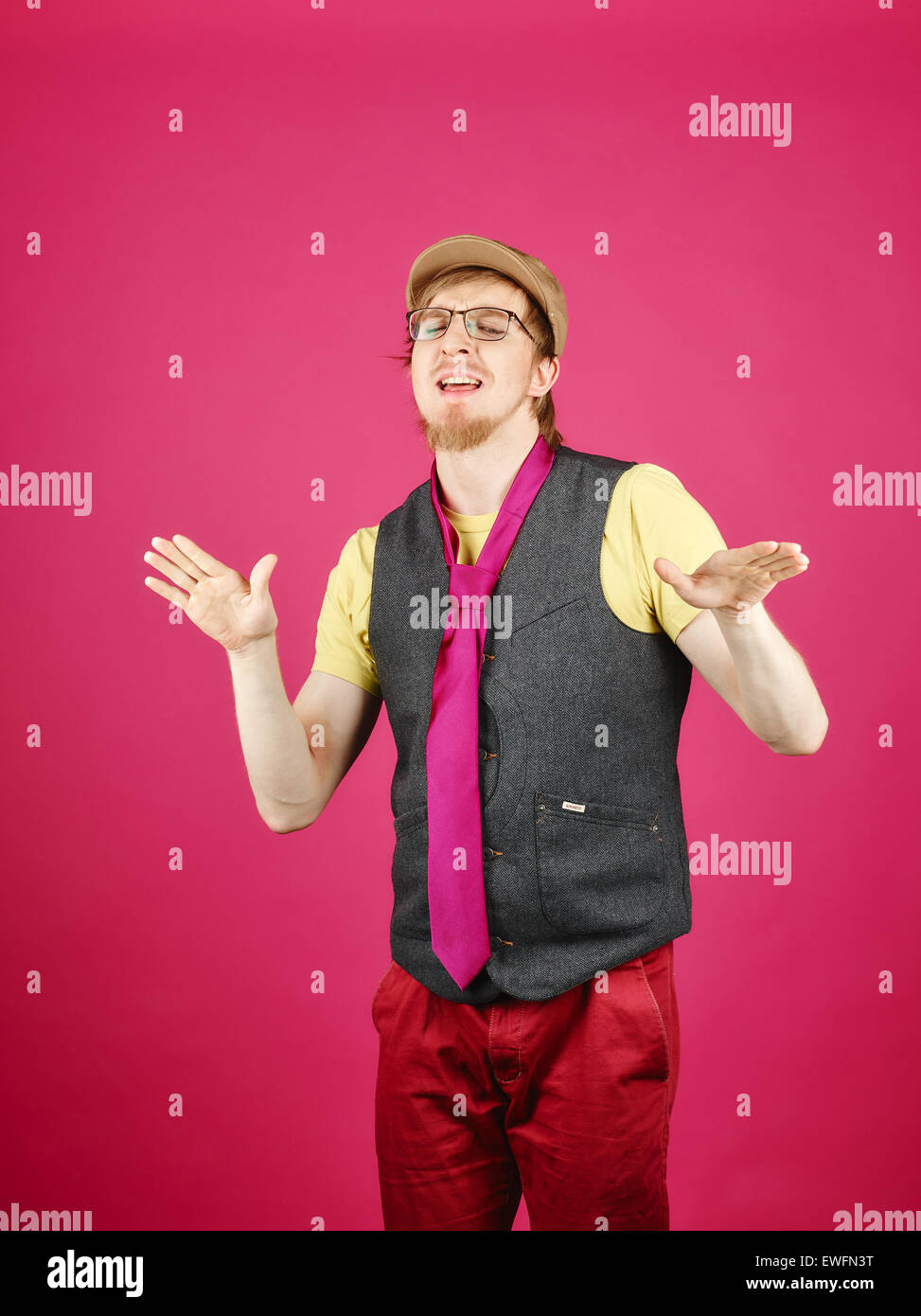 Expressive hipster wearing a vest and pink tie, pink background and ...