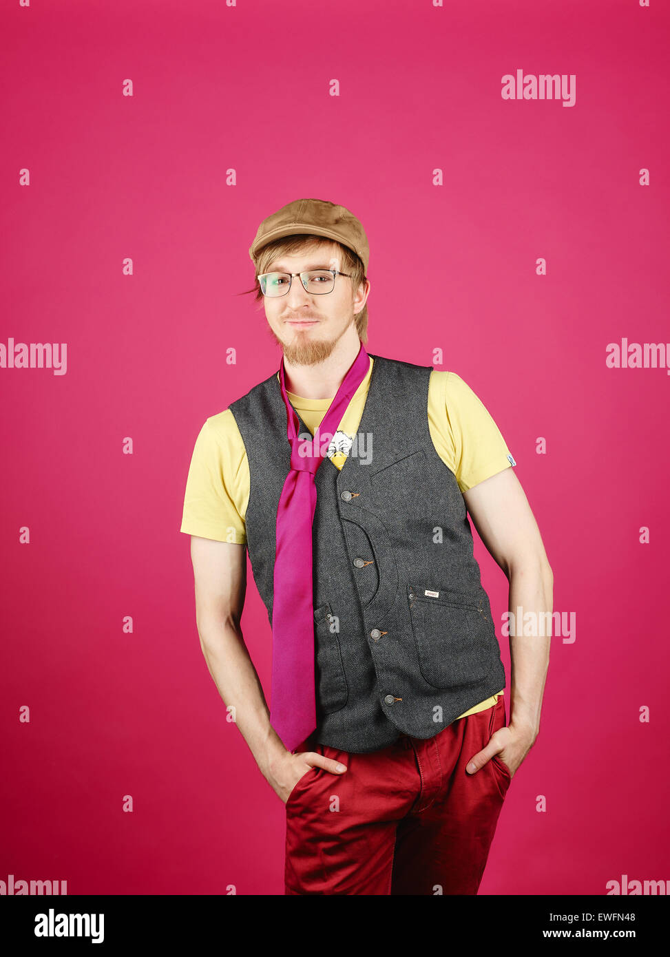 Expressive hipster wearing a vest and pink tie, pink background and ...