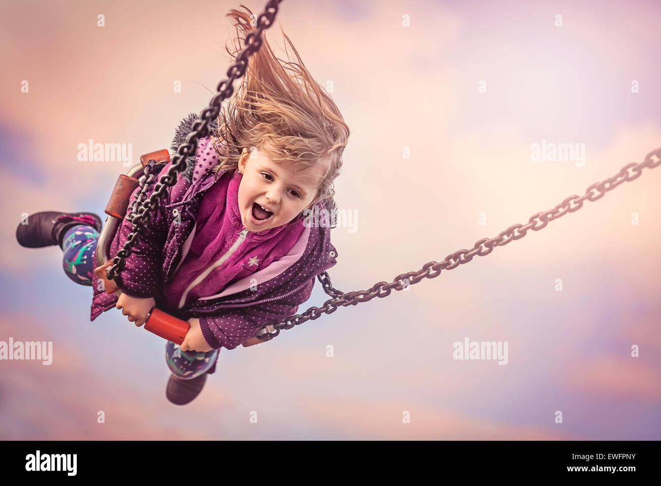 Young girl having fun on a sling in a playground Stock Photo - Alamy