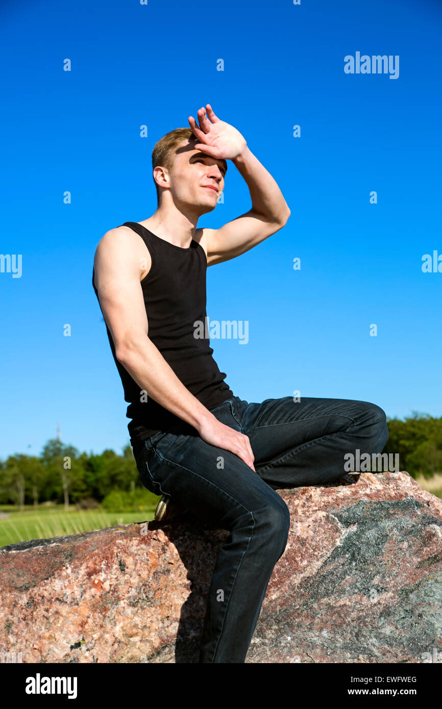 Young man hiding eyes from the sunlight Stock Photo - Alamy