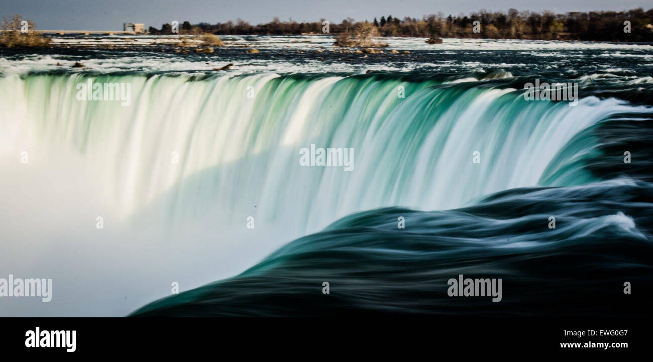 A large waterfall cascades down a rocky cliff, creating a stunning ...