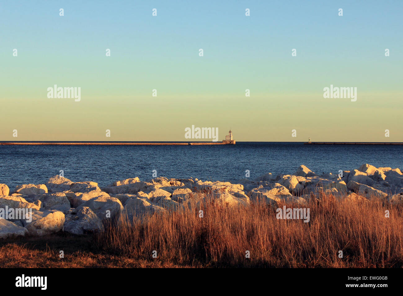 A lighthouse standing tall in the middle of blue ocean waters ...