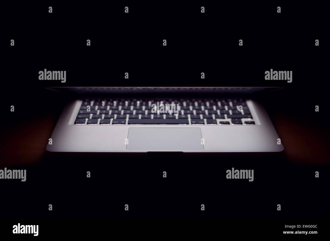 A close-up silhouette of a MacBook keyboard, highlighting the keys and ...