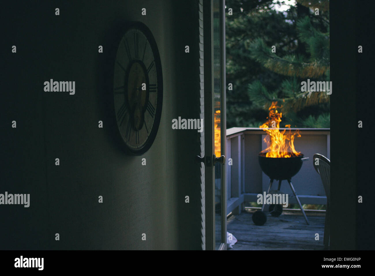 This image shows a grill with flames rising from it, giving off intense ...