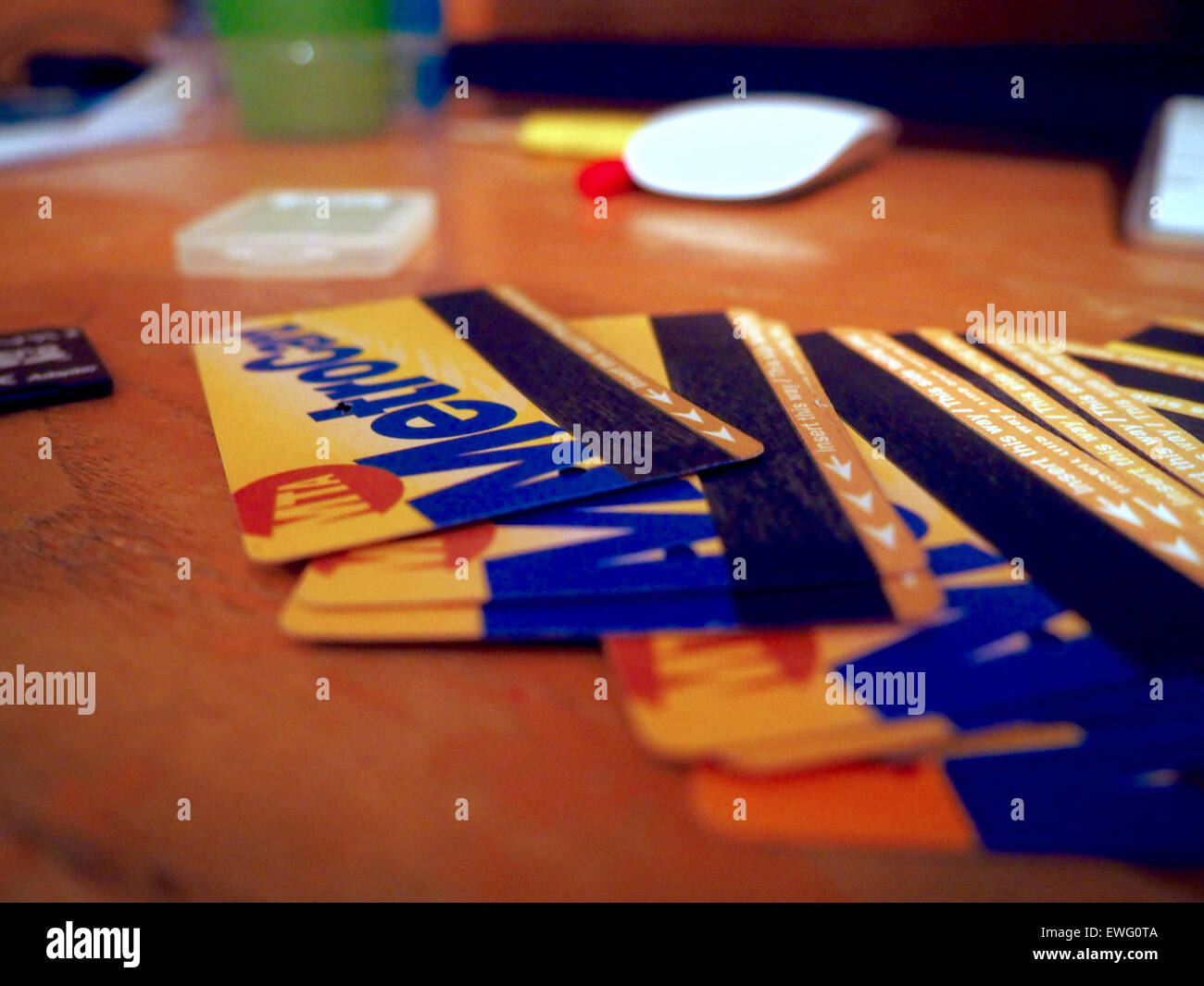 A group of metro cards is arranged on a desk surface. The cards are ...