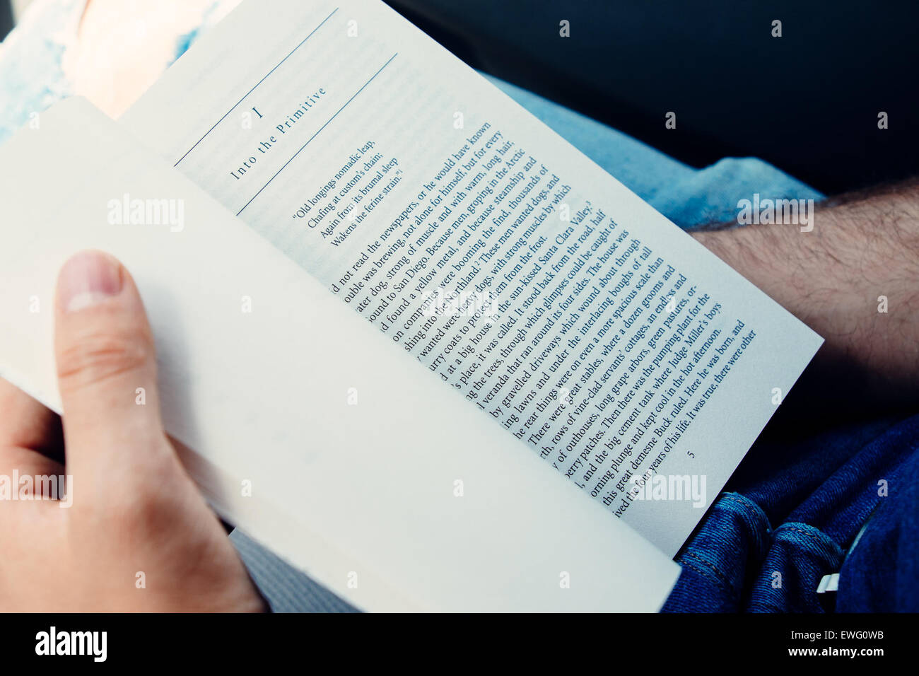 An image of hands holding an open book while reading. The book is ...