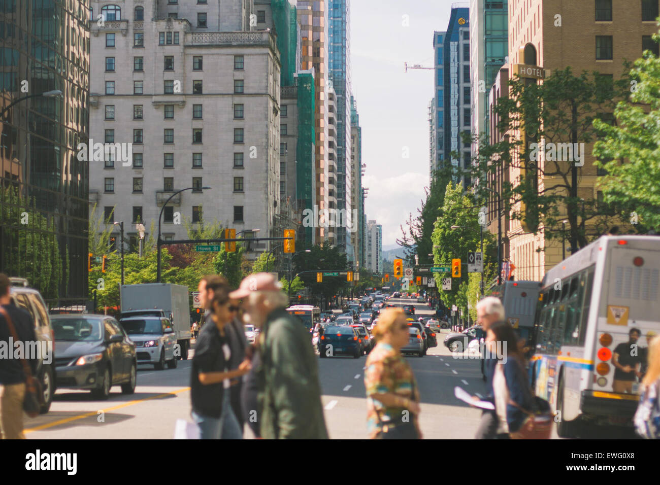 A busy city crosswalk on Howe Street, with skyscrapers towering in the ...