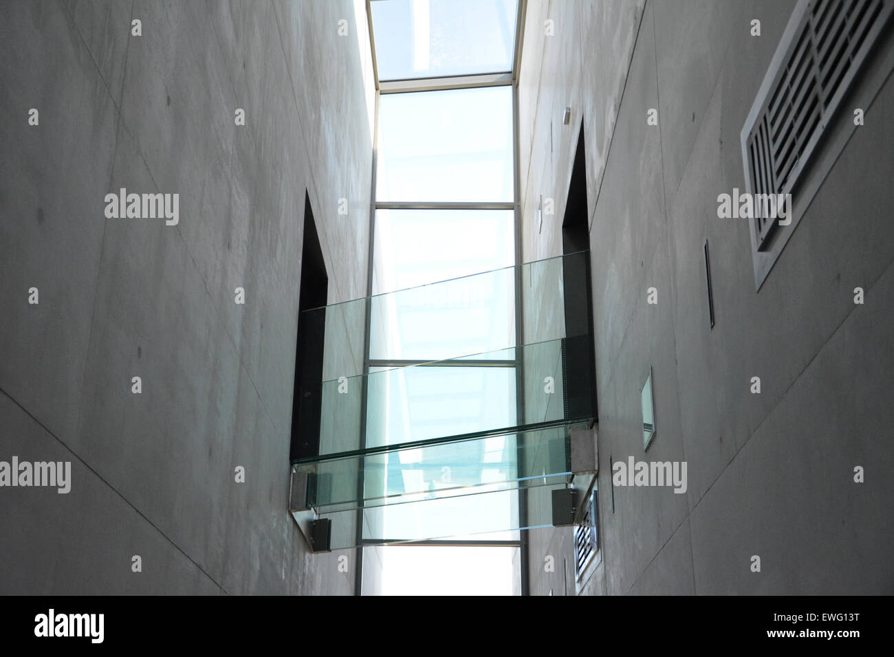 An indoor glass bridge illuminated by natural light from a skylight ...