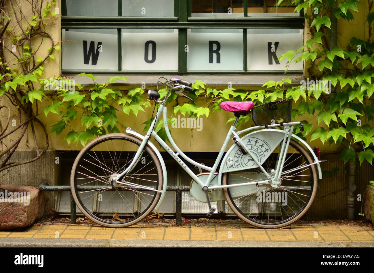 This image shows a bicycle placed outside a window with a work sign ...