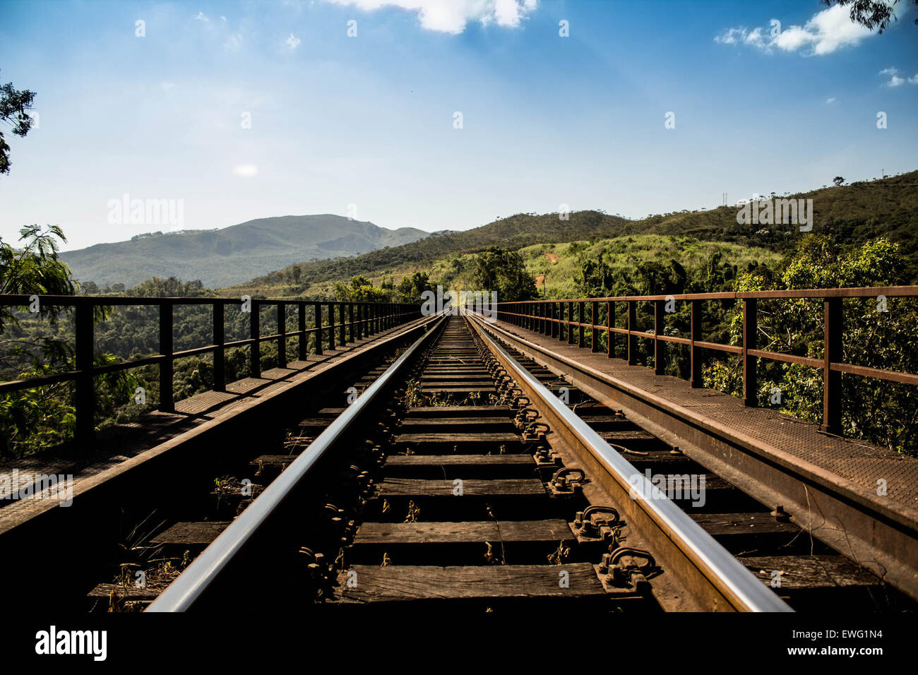 A scenic view of railroad tracks stretching through a mountainous ...