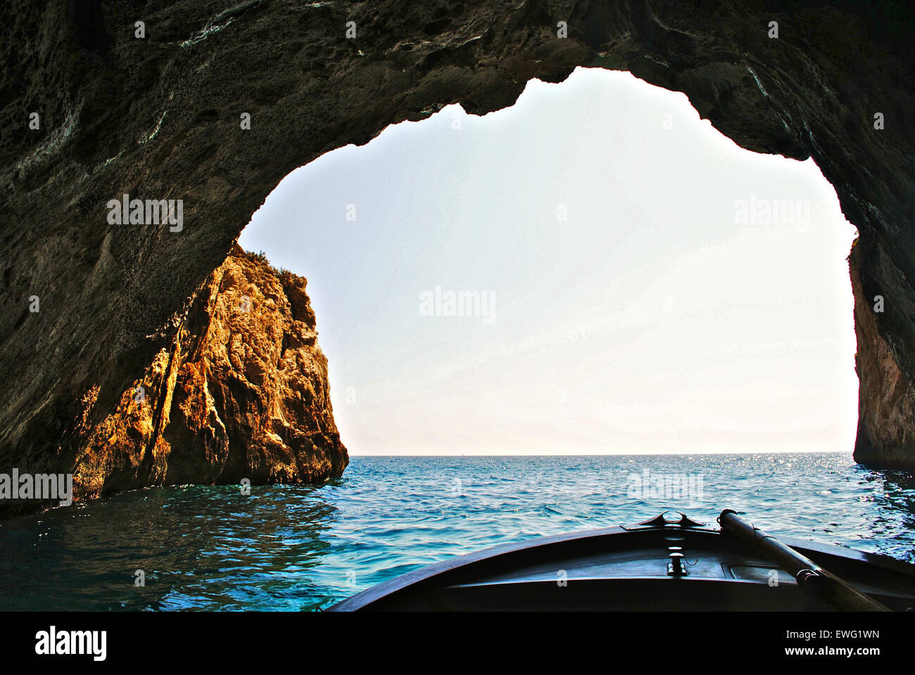 A rock formation tunnel beneath the ocean with a boat entrance. The ...