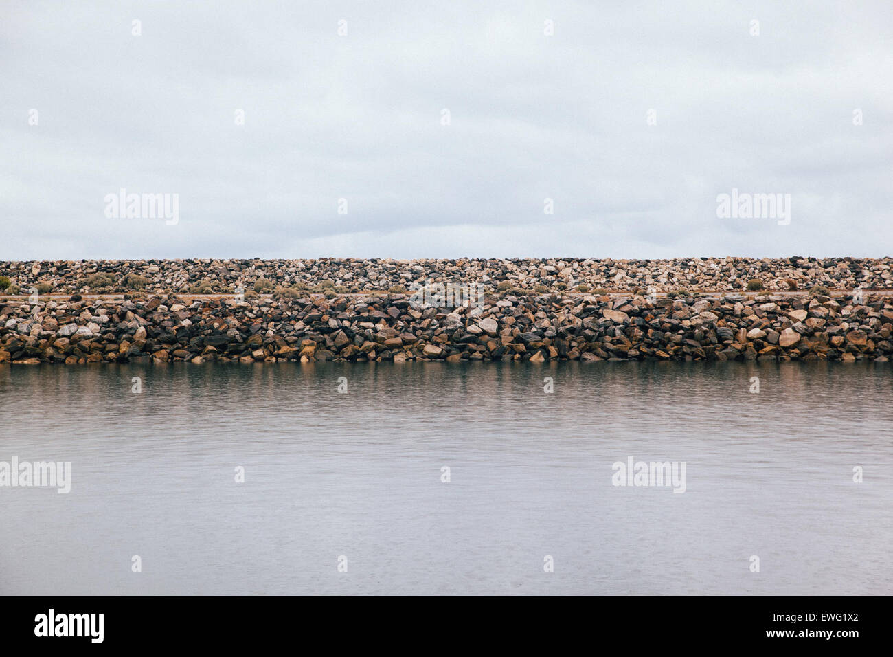 A peaceful coastal scene with rocks and pebbles lining the shore of a ...