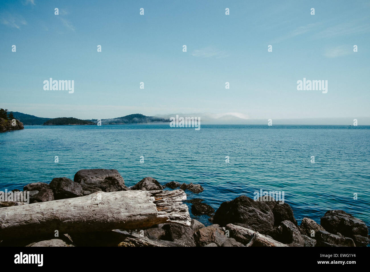 A calm blue lake nestled between mountains, with clear water reflecting ...