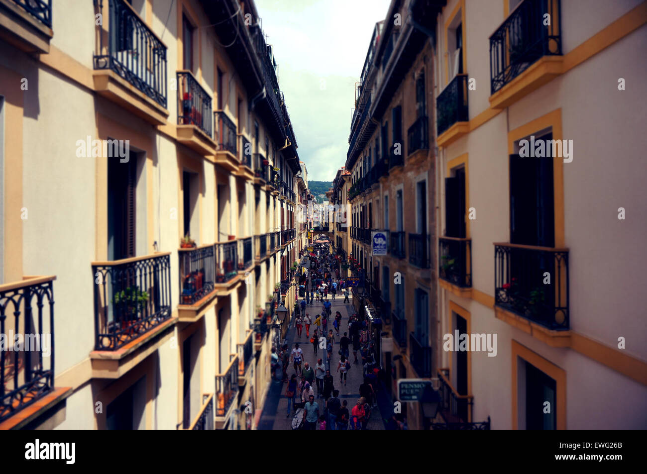 A busy walkway between two buildings, filled with people and activity ...