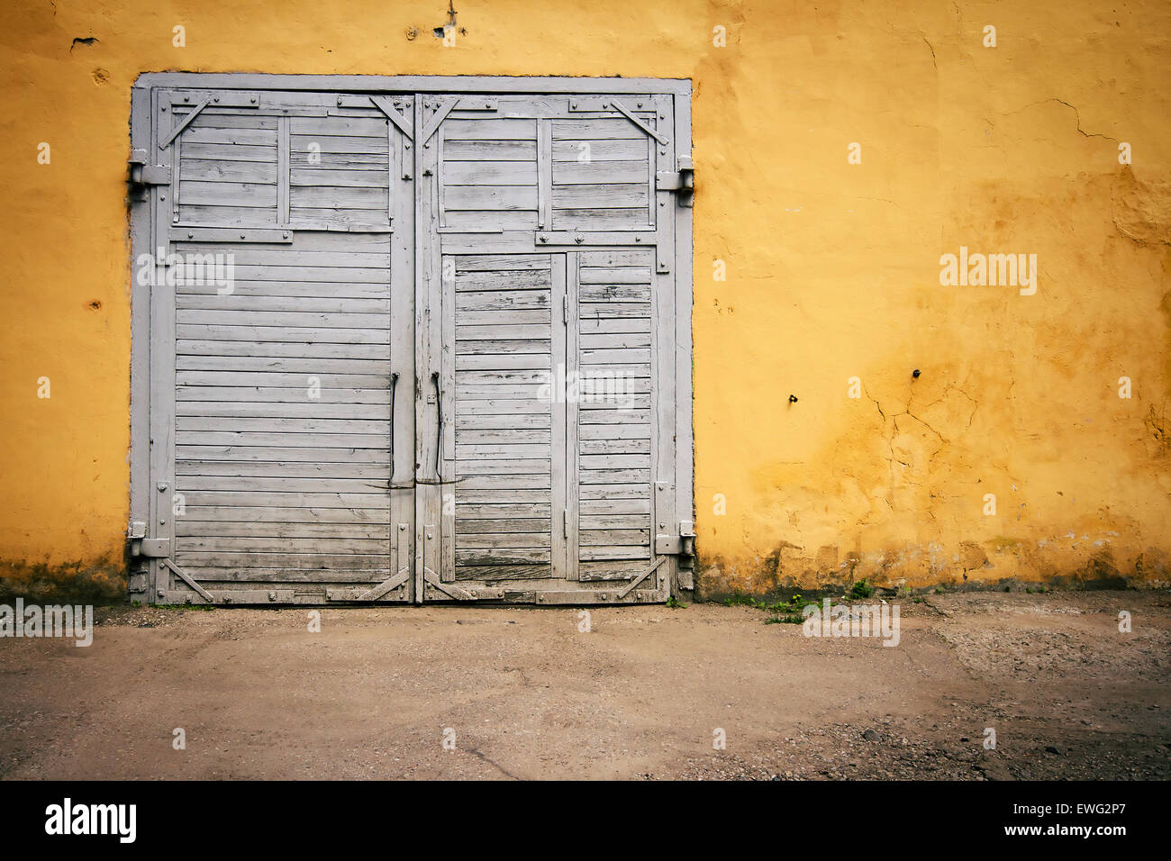 Old wooden gate in grungy yellow wall Stock Photo - Alamy