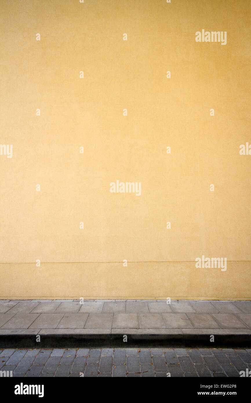 Newly built yellow wall and pavement Stock Photo - Alamy