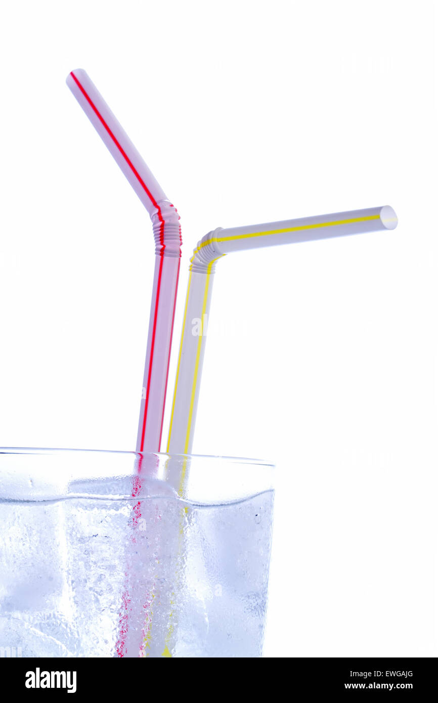 two straws in a glass with water and ice over white background Stock ...