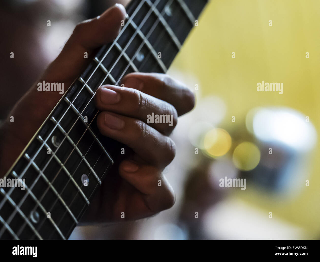 Man playing on guitar with focus on hand and headstock. 21st June, 2015 ...