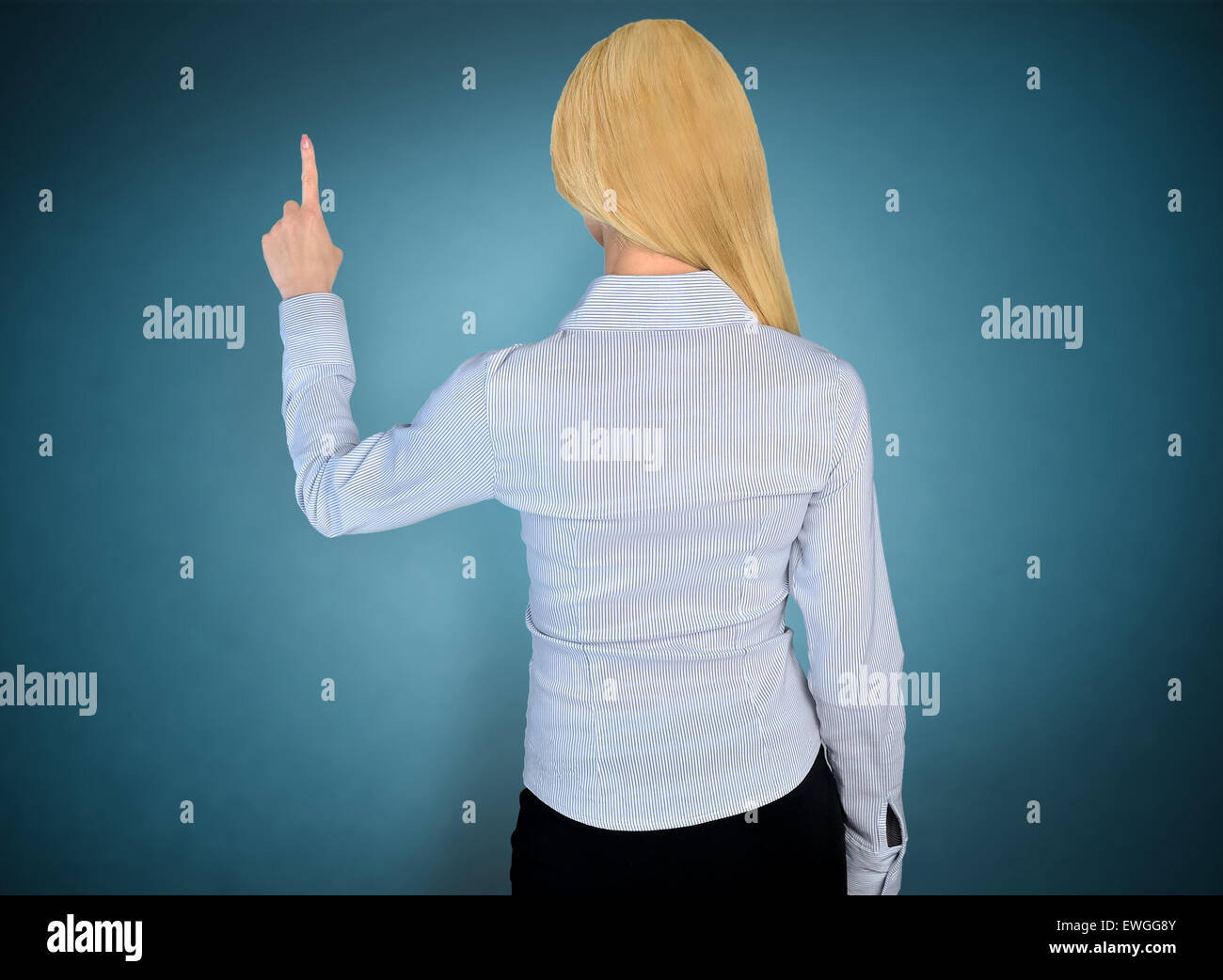 Woman pressing something on blue background Stock Photo - Alamy