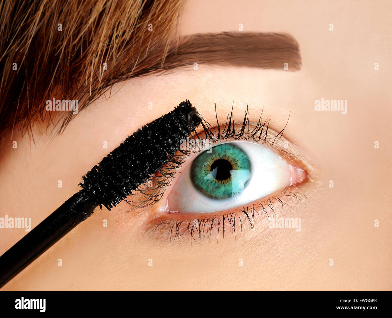 Woman applying mascara on eye Stock Photo - Alamy