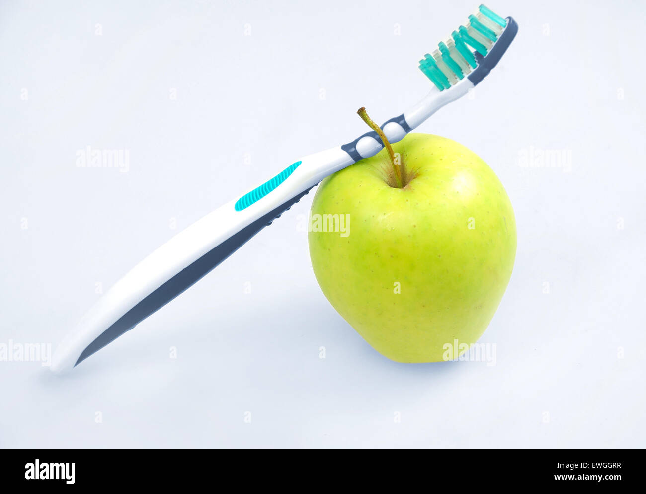 Apple with tooth brush on grey background Stock Photo - Alamy