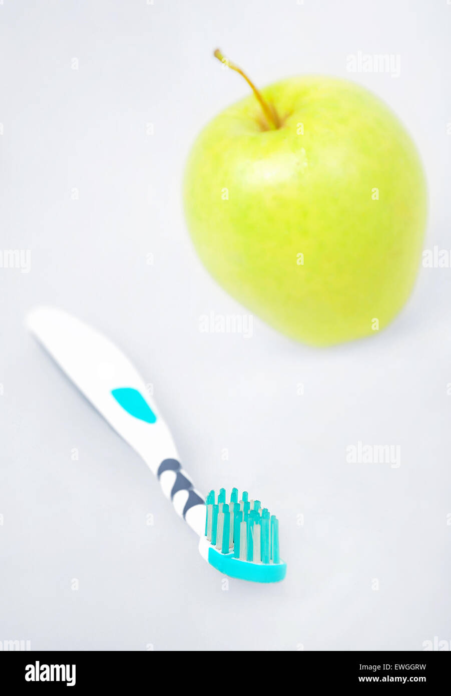Apple with tooth brush on grey background Stock Photo - Alamy