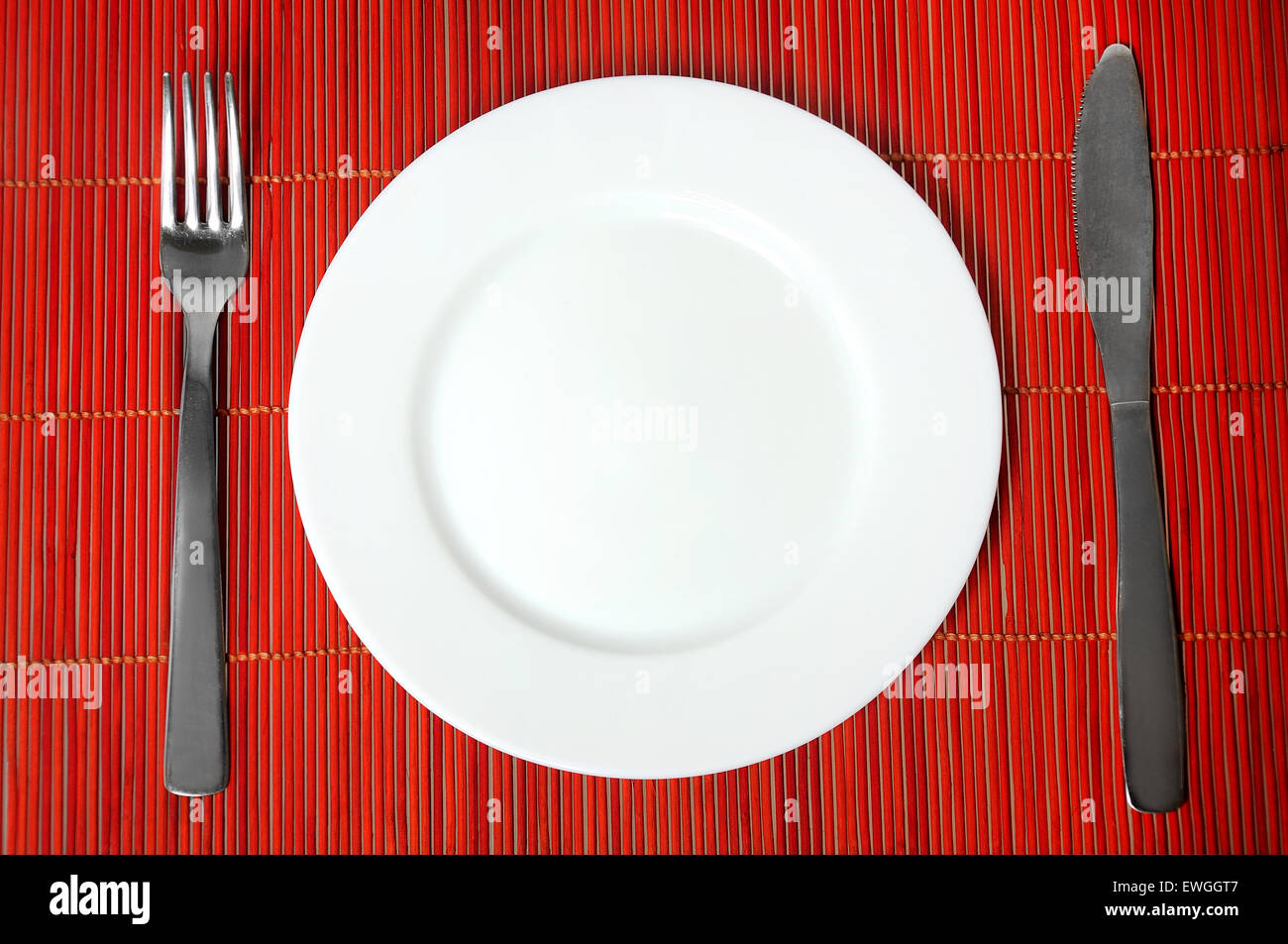 Empty plate and utensils on table Stock Photo - Alamy