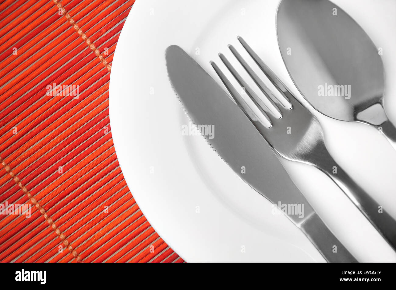 Empty plate and utensils on table Stock Photo - Alamy