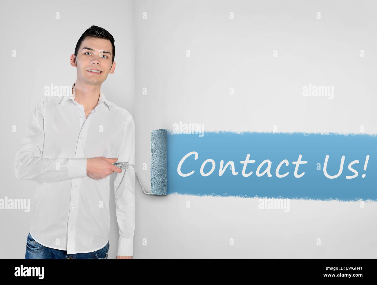 Young man painting Contact us word on wall Stock Photo - Alamy
