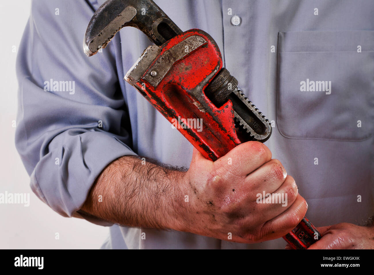 Stock image of plumber in uniform holding pipe wrench Stock Photo - Alamy