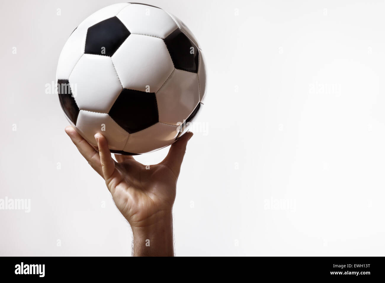 male hand holding up a traditional black and white football Stock Photo ...