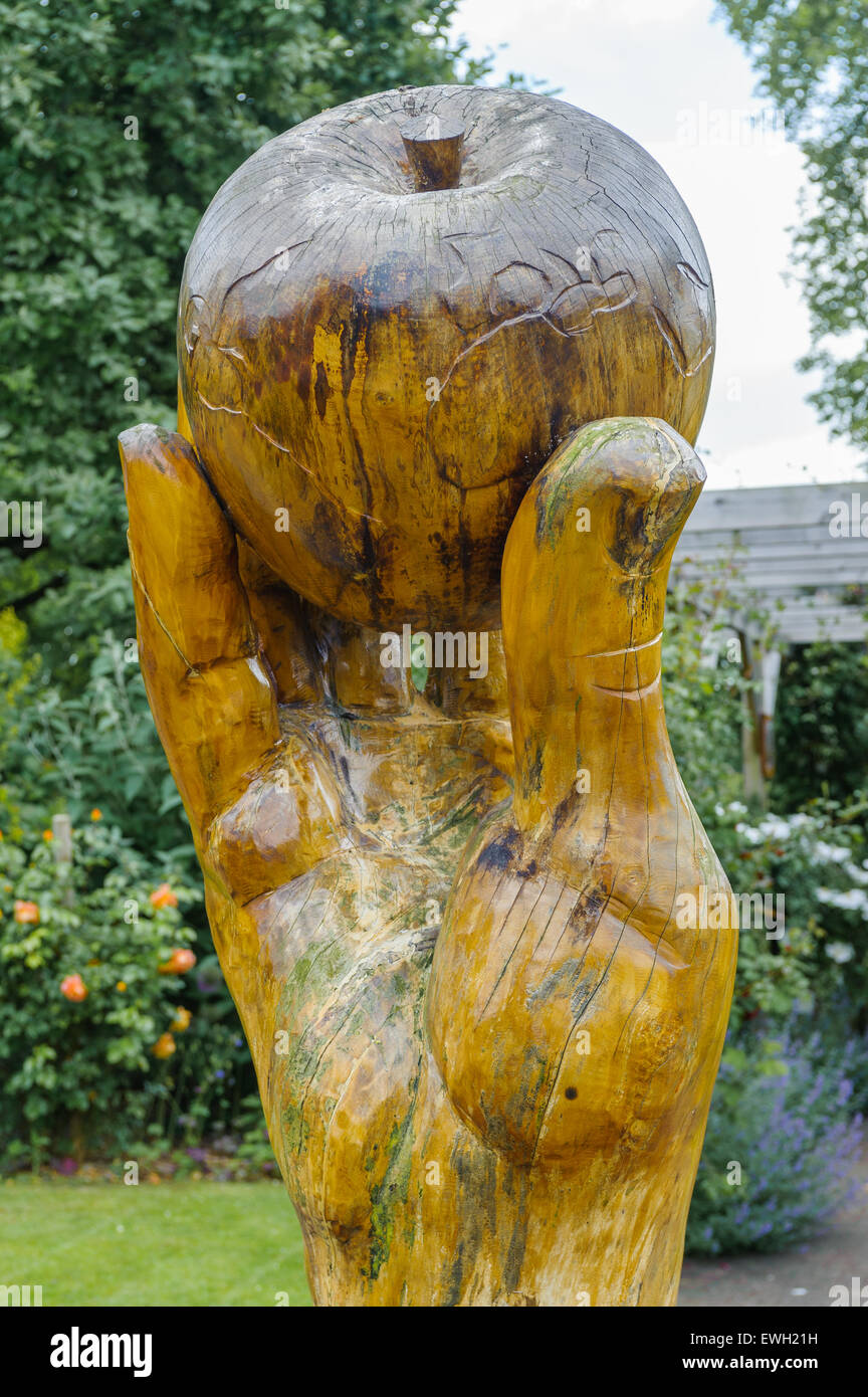 A carving, from an old tree, of a hand holding an apple in Wyndham Park ...