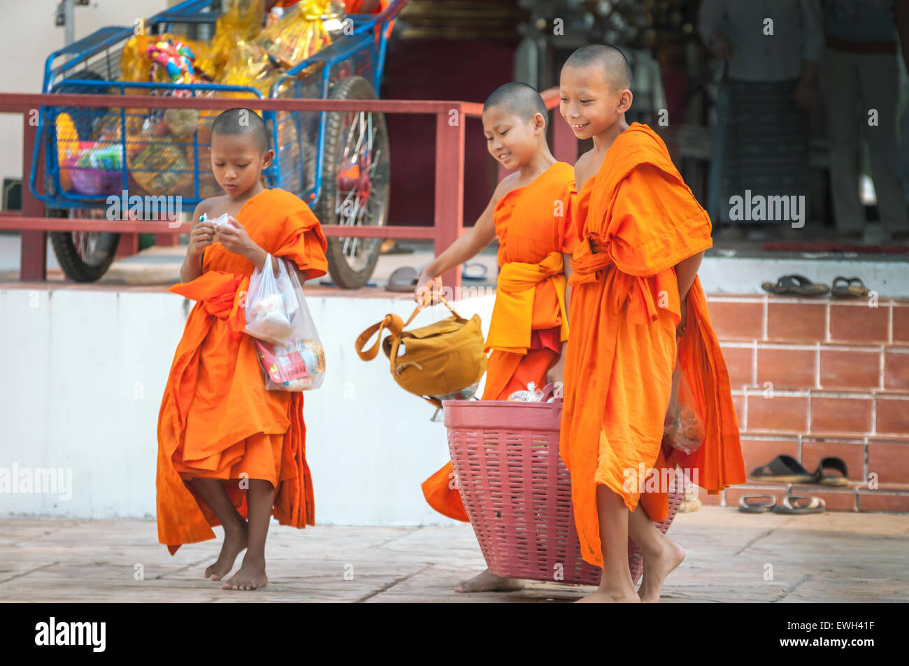 Young monks carrying a basket of offerings from the main prayer hall of ...